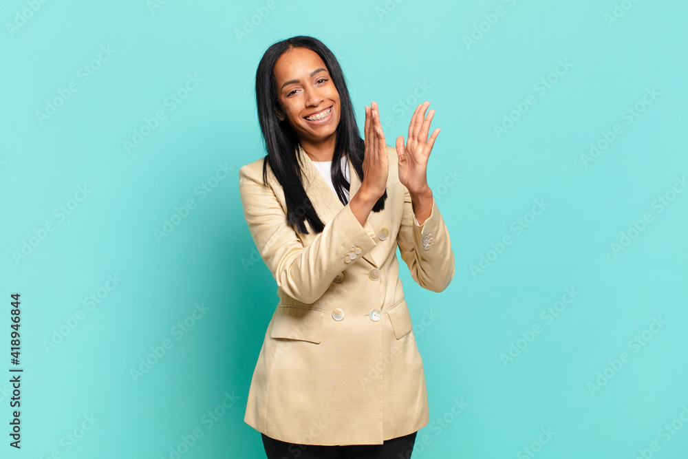 young black woman feeling happy and successful, smiling and clapping ...