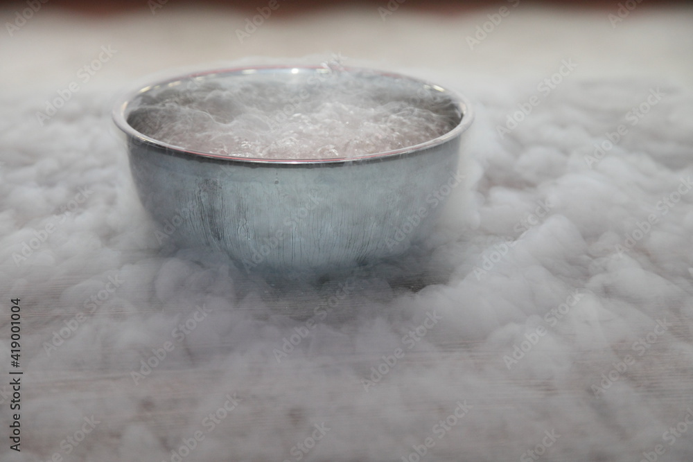 Liquid nitrogen in stainless steel bowl on table with transpiration ...