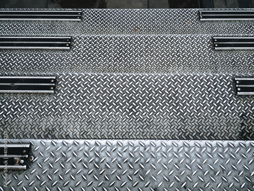 Vintage wet background of metal diamond plate in a gray silver color ...