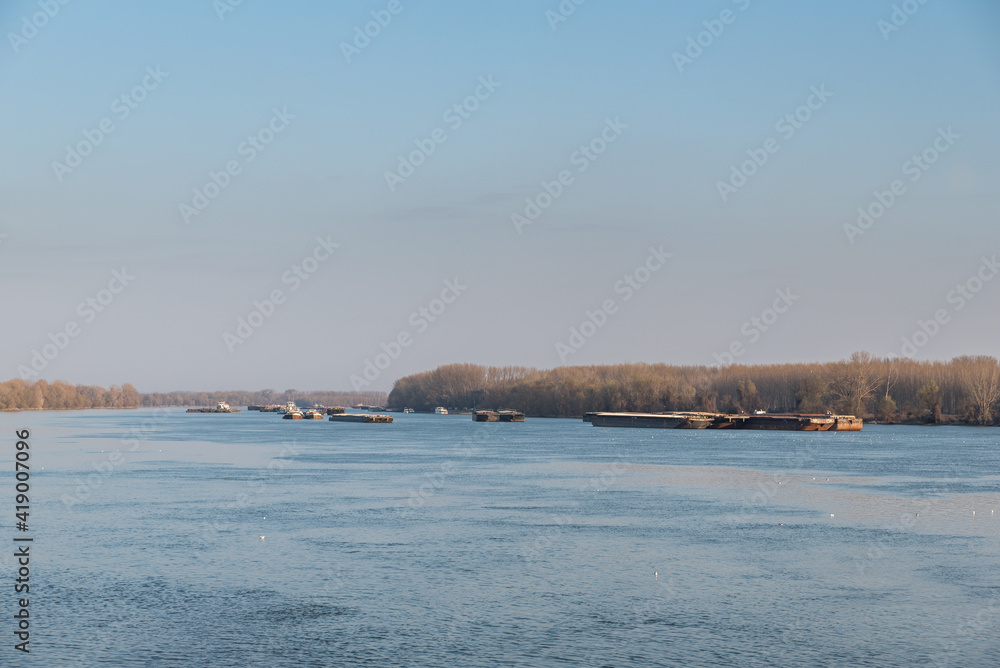 Oil and cargo barges anchored on the river with the anchor lowered into ...