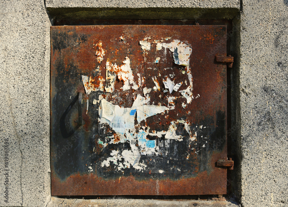 rusty metal door embedded in a wall with red, black and orange tones ...