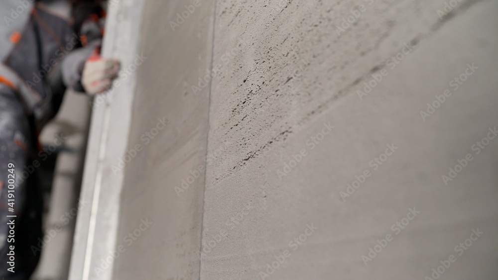 Aligning the wall with wire. Leveling the mortar. A mortar worker uses ...