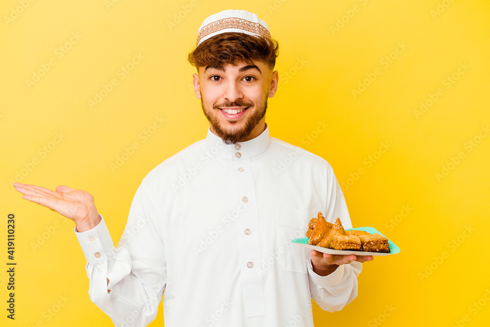 Young Moroccan man wearing the typical arabic costume eating Arabian ...