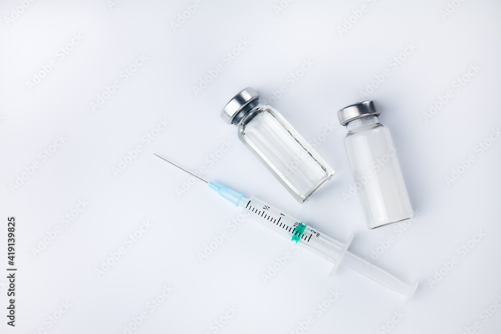 Syringe injection, vaccine vial and medicine drug bottles and on a ...