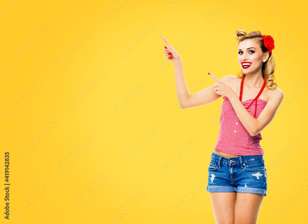 Amazed happy woman pointing at something. Excited girl in pin up ...