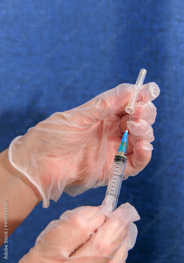 Nurse holds syringe for injection and removes cap from syringe Stock ...