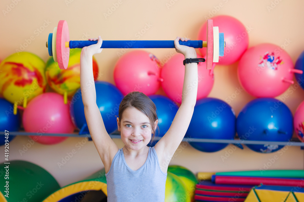 Little girl lifts a barbell in the gym Stock Photo | Adobe Stock