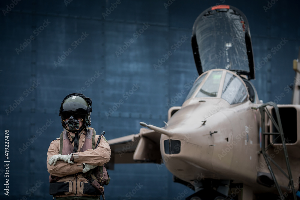 Fighter Pilot wearing helmet and visor standing next to fighter jet ...