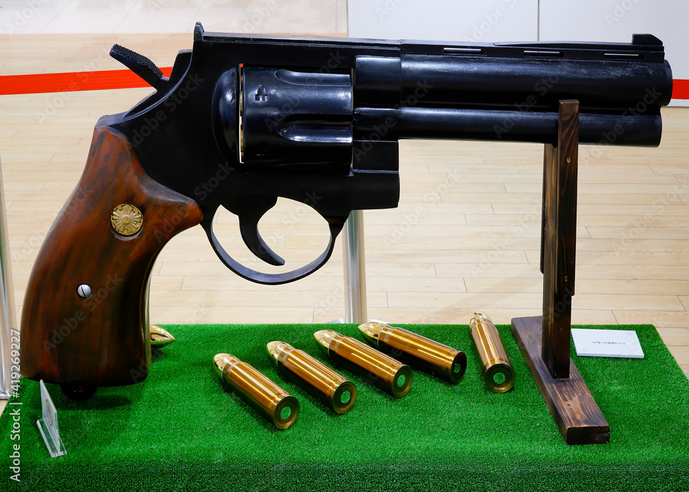 Close up on a real size replica of the hand revolver canon and bullets ...