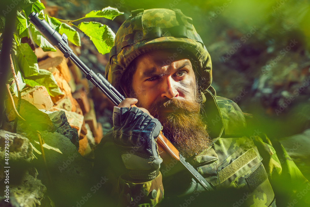 Soldier with sad face in military helmet and camouflage with gun on ...