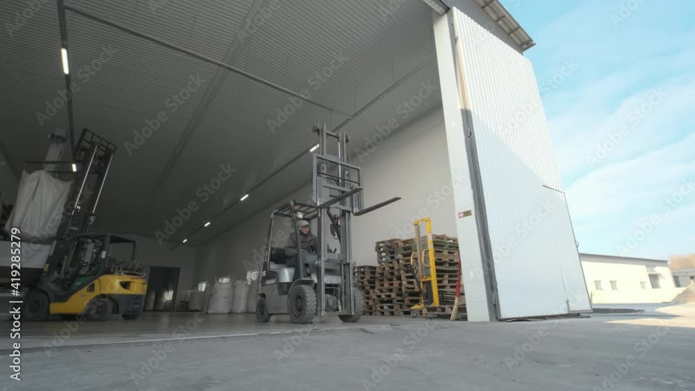 Warehousing. Forklift driver stacking big bag of raw material in ...