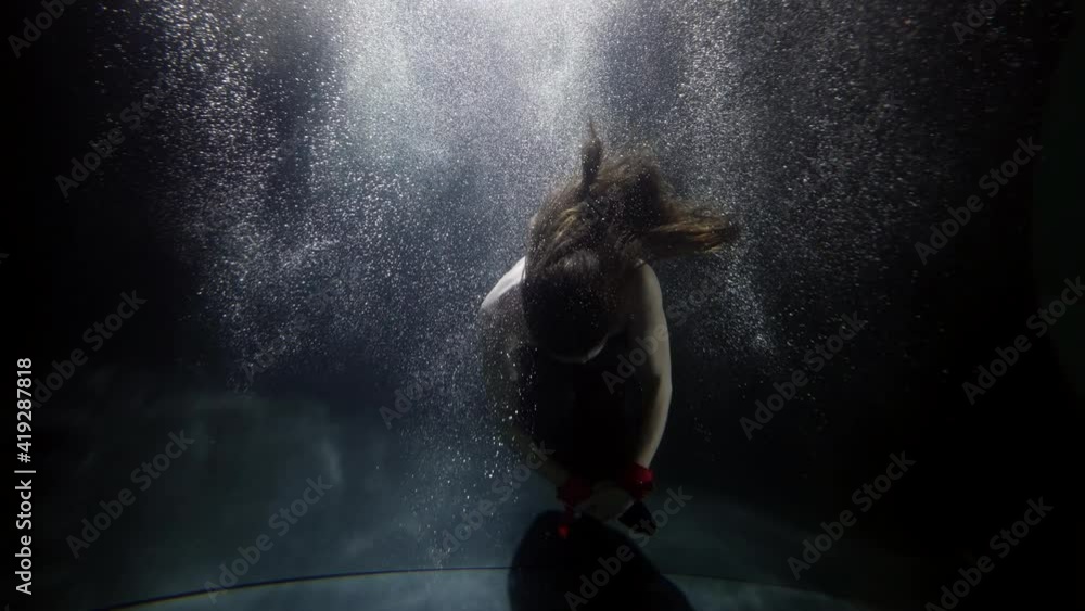 mystery underwater shot with floating female figure, slow motion in ...