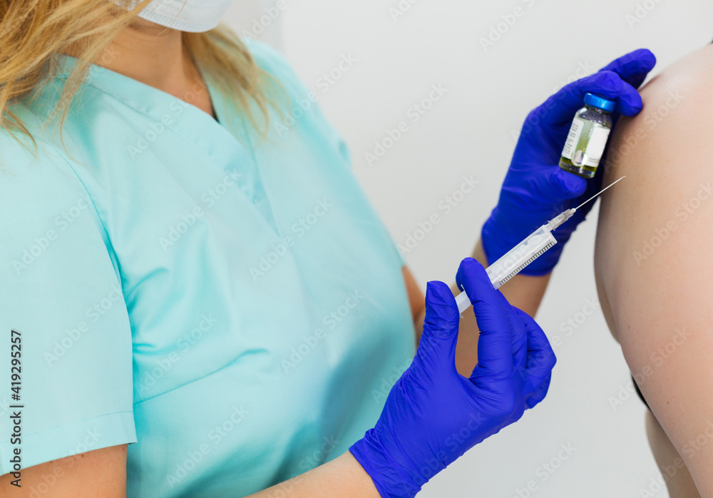 Close up of a Doctor making a vaccination in the shoulder of patient ...