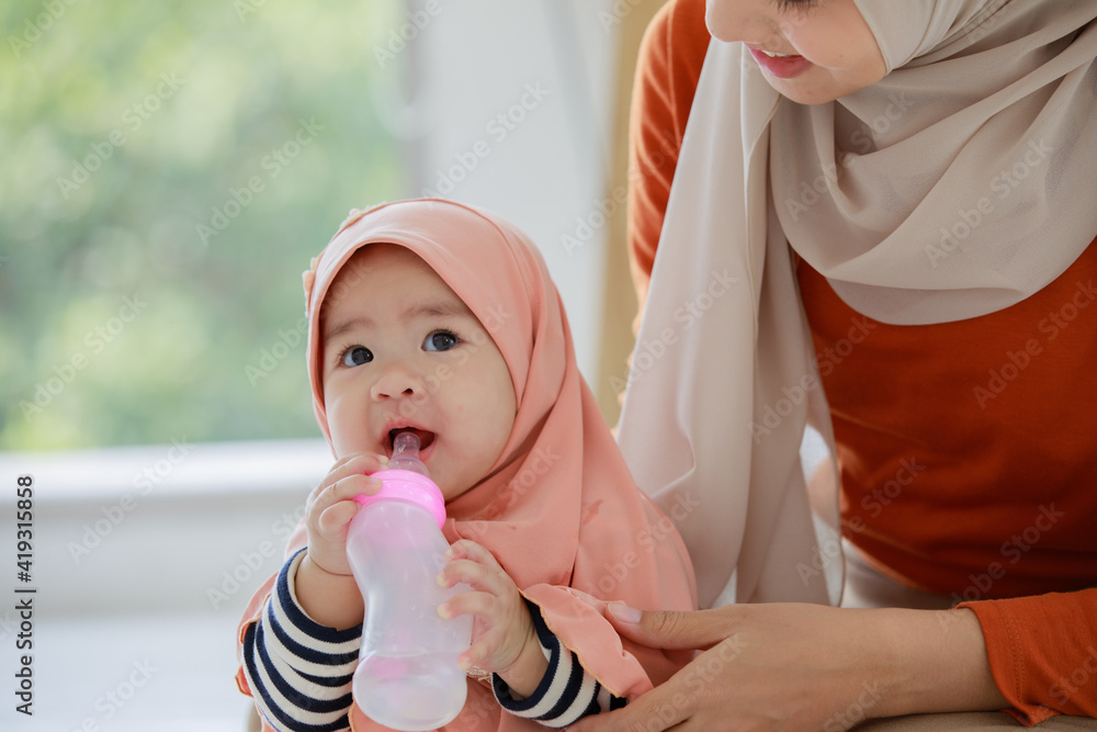 Muslim Newborn baby smile with milk power bottle.Muslim family mom and ...
