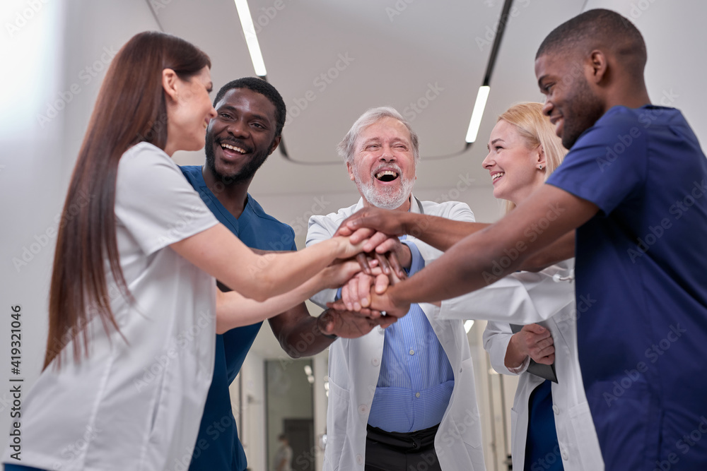 Team of diverse positive medical doctors putting hands together. Unity ...