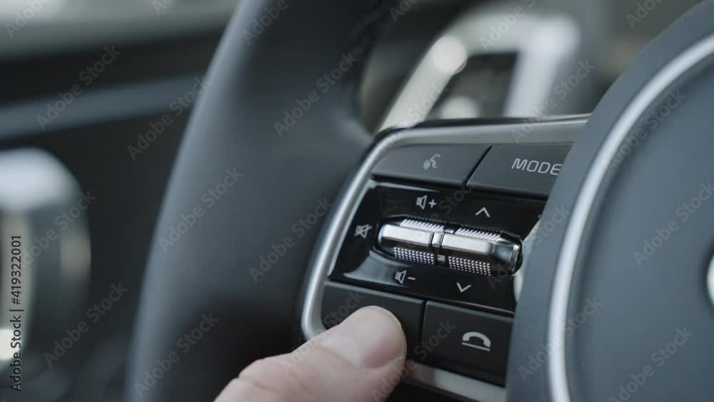 Close up of finger pressing the audio control buttons to increase or ...