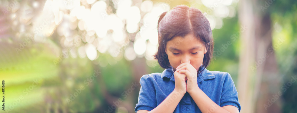 Prayer concept. Asian child praying, hope for peace and free from ...