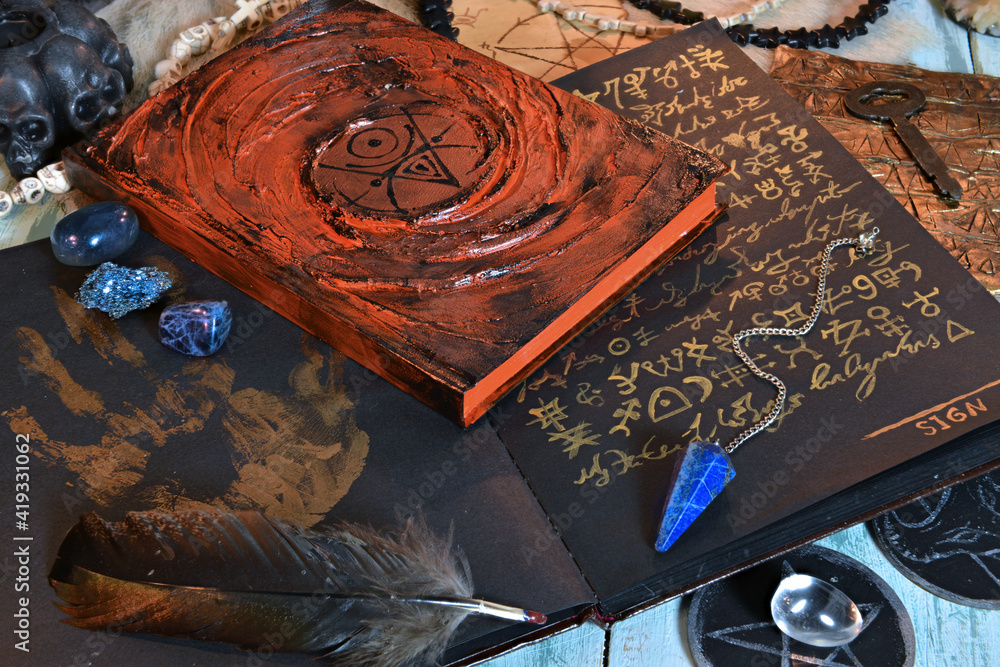 Decorated magic books of spells with quill and devil symbols on witch ...