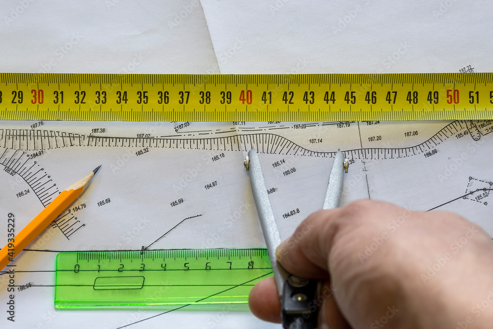 The planner checks the dimensions on the elevation drawing with a ...