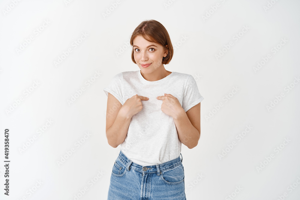 Shy cute girl pointing at herself, me gesture, blushing and looking ...