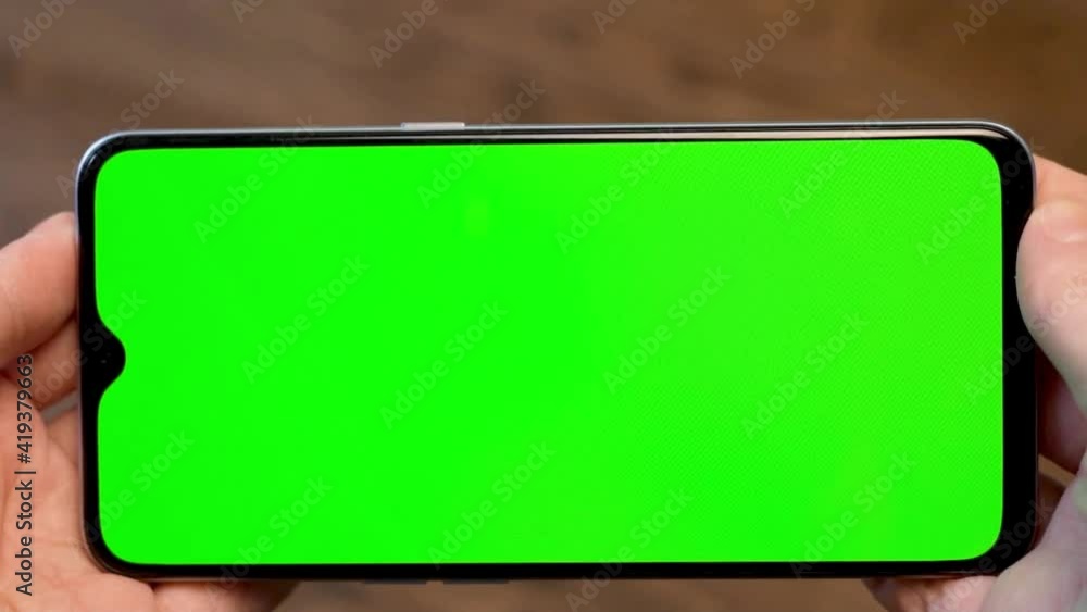Hands Hold The Phone Horizontally with A Green Screen, Green Background ...