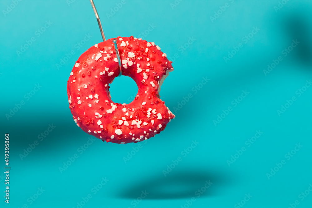 Donut on fishing hook on colored studio background. Concept calorie ...