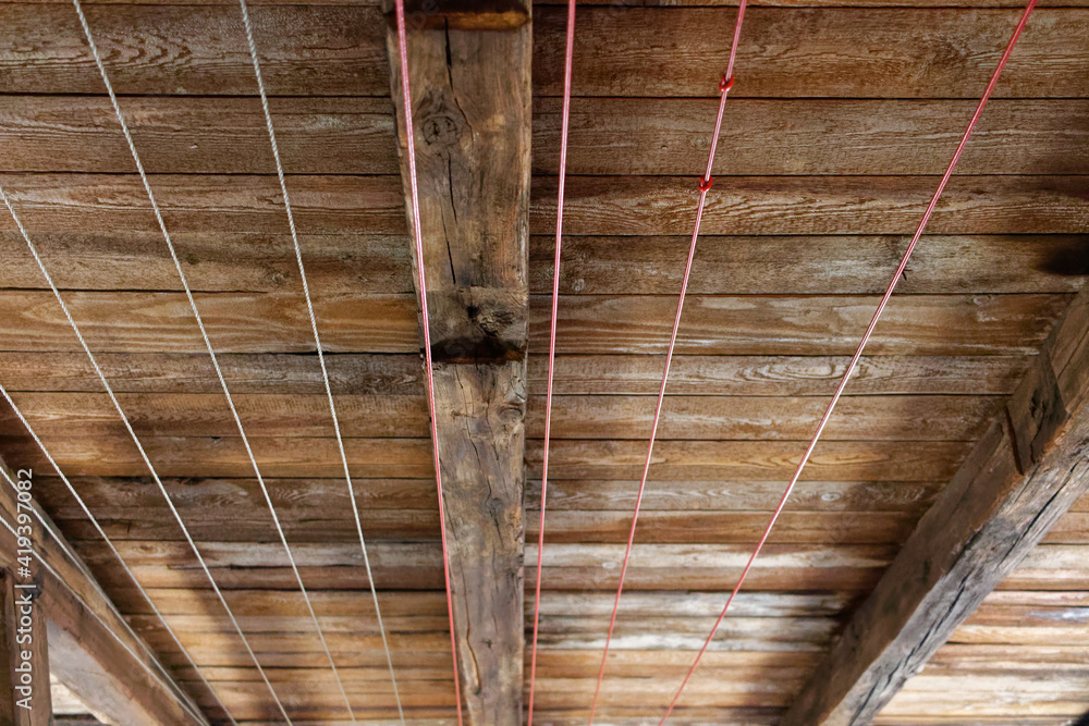 Stary strych. Dach z drewnianych belek i desek. Sznurki na bieliznę i ...