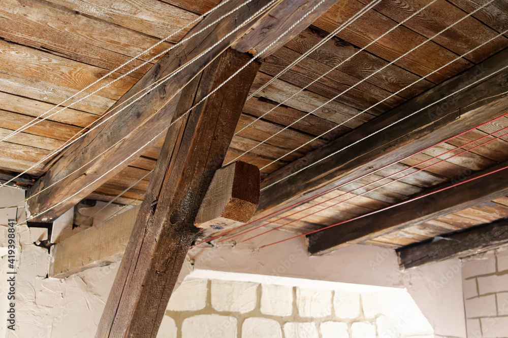 Stary strych. Dach z drewnianych belek i desek. Sznurki na bieliznę i ...