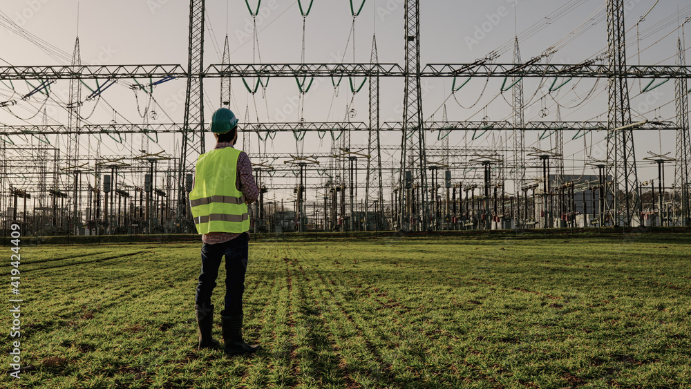 Electrical engineer wearing a helmet and safety vest working with ...