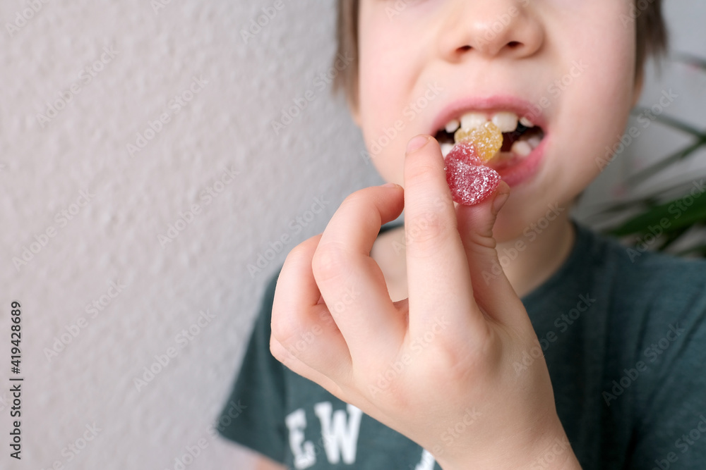 little child, kid eating sweet gelatin candies, looking forward to ...