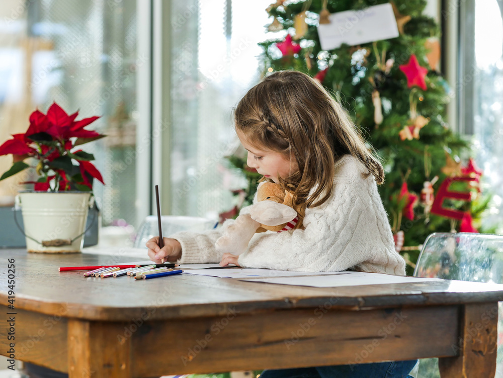 Crop little girl drawing with multicolored pencils on paper sheet in ...