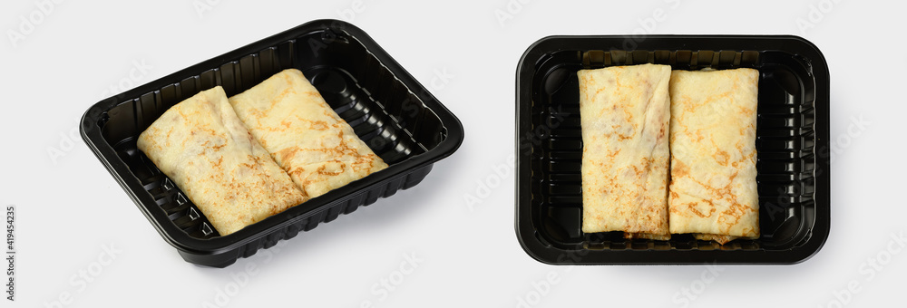 pancakes with filling in a black plastic container on a white ...