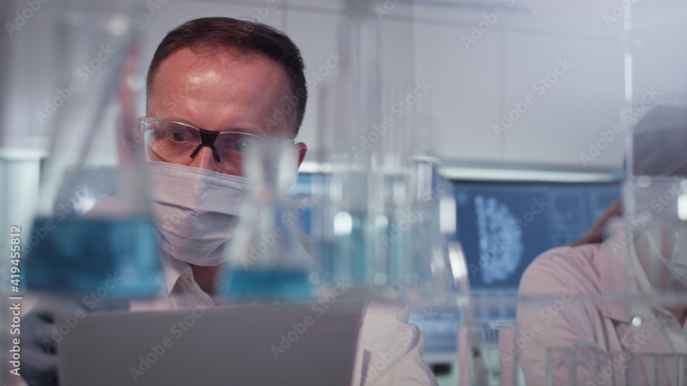 Diverse scientists studying human skeleton and DNA. Using computers and ...