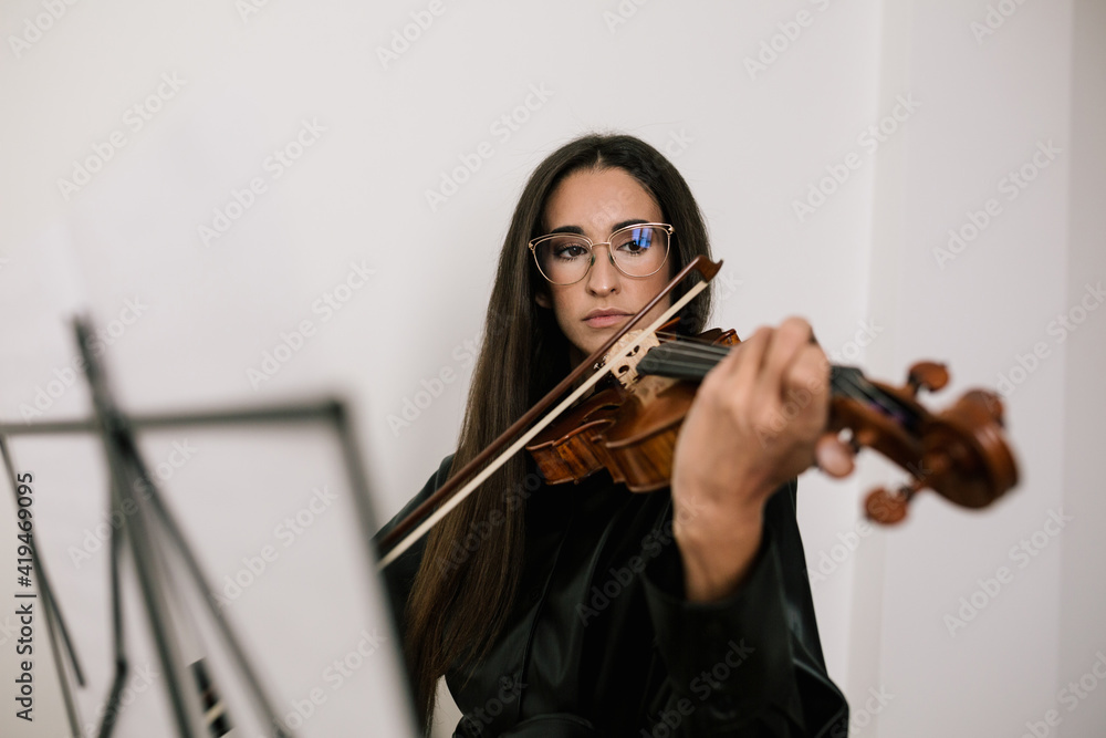 Serious artist playing stringed musical instrument while practicing ...