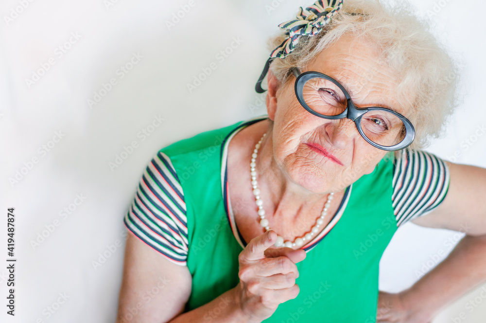 Stylish emotional elderly woman with an evil face waving index finger ...