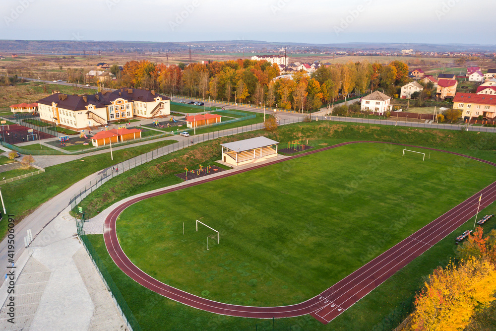 Aerial view of sports stadium with red running tracks and green grass ...