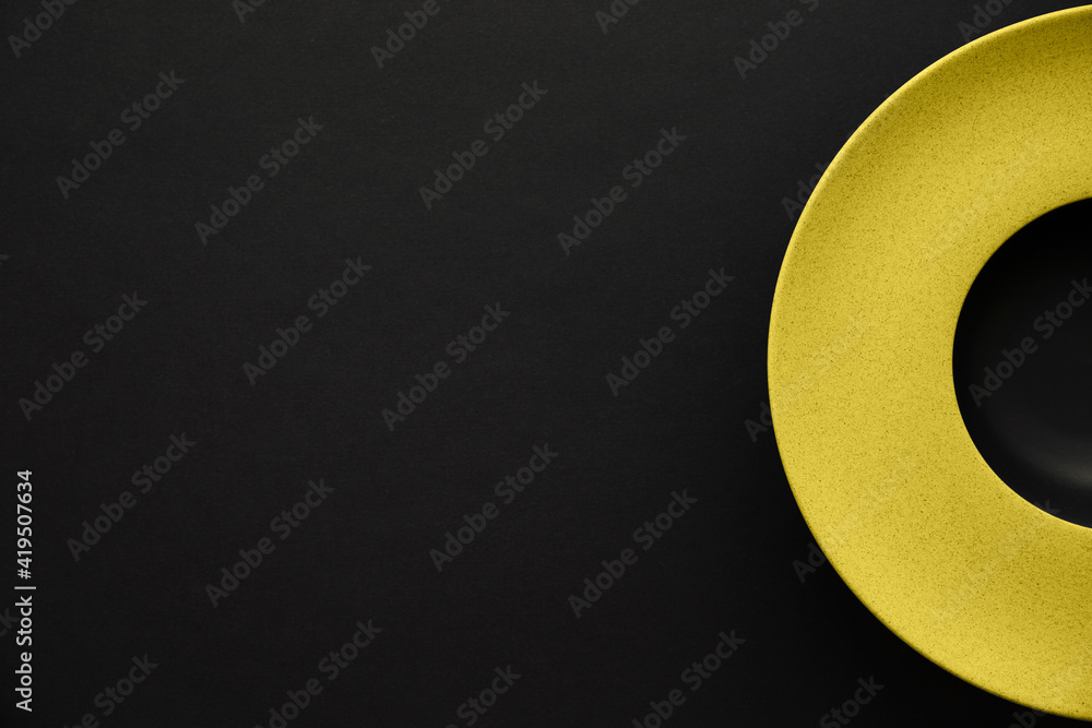 Top view of an empty yellow and black pasta plate, half visible, on a ...