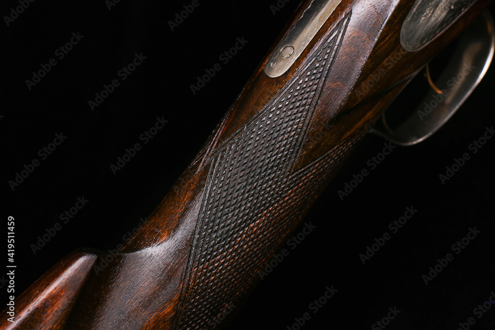 Details of an elegant double-barreled hunting classic shotgun on a black background close-up ...