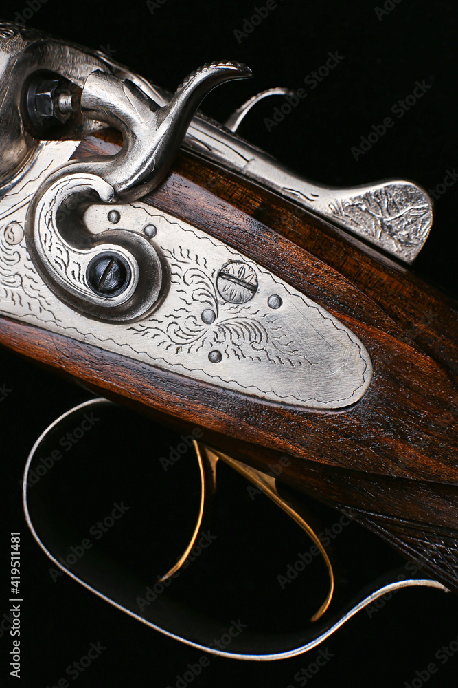 Details of an elegant double-barreled hunting classic shotgun on a black background close-up ...