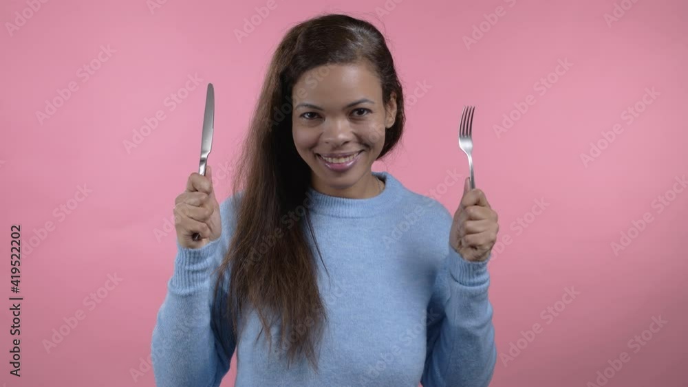 Portrait of hungry african woman with fork and knife. Girl waiting for ...