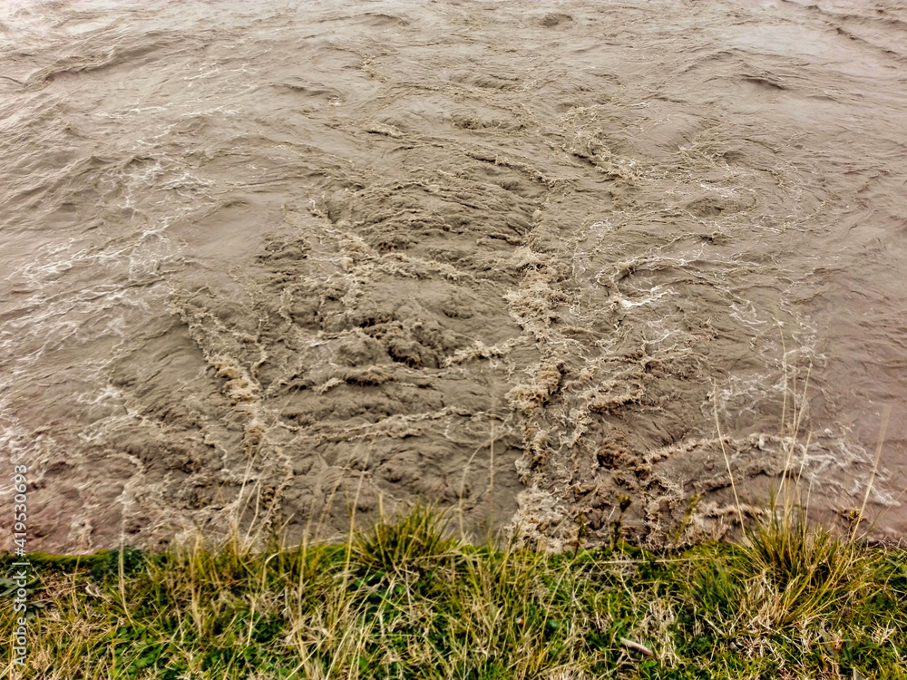 Water flood on river after storm rain. Dirty muddy water flow of stream ...