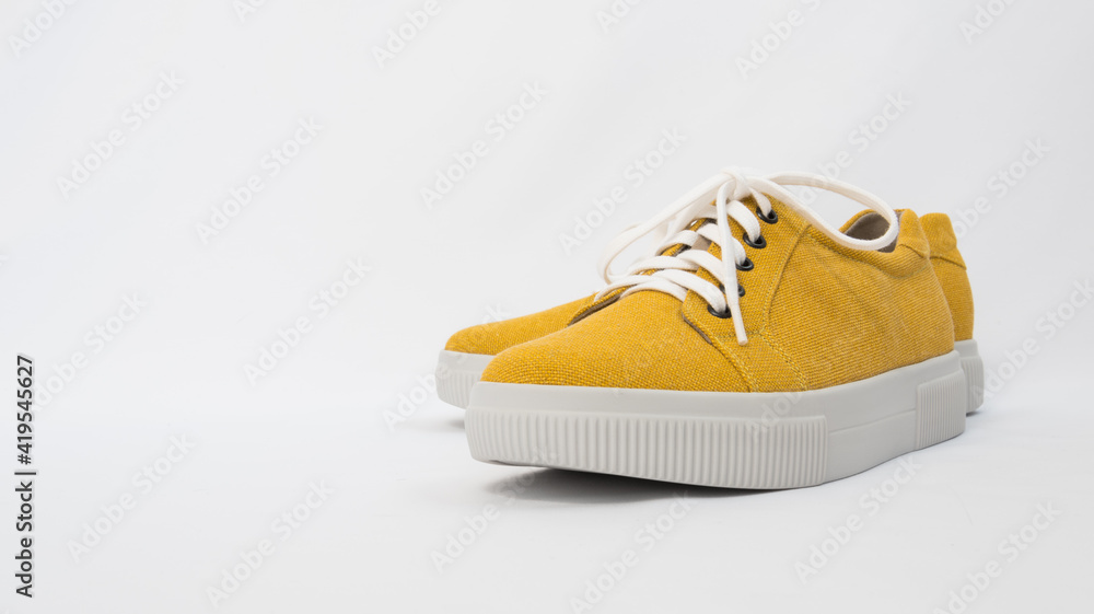 Side view of fashionable mustard-colored shoes. Sneakers on a white ...
