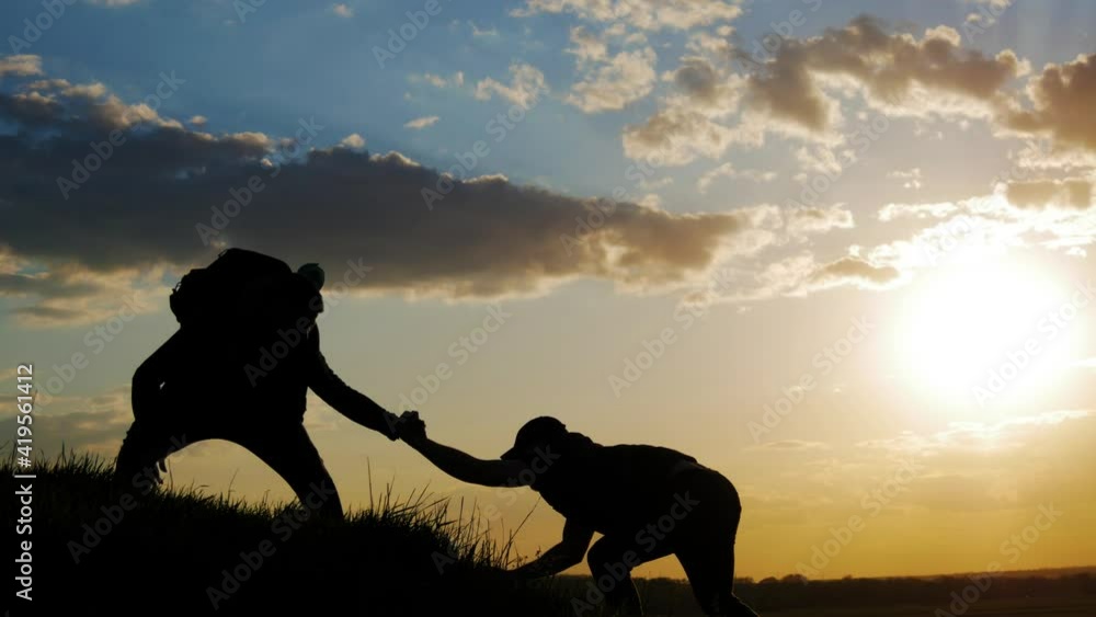 Helping Hand. Man giving hand a male to help her to climb the mountain ...