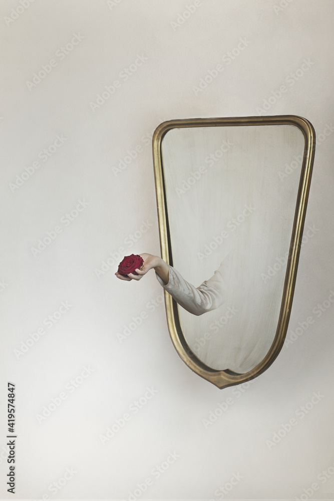 surreal gesture of a hand coming out of the mirror to give a rose Stock ...