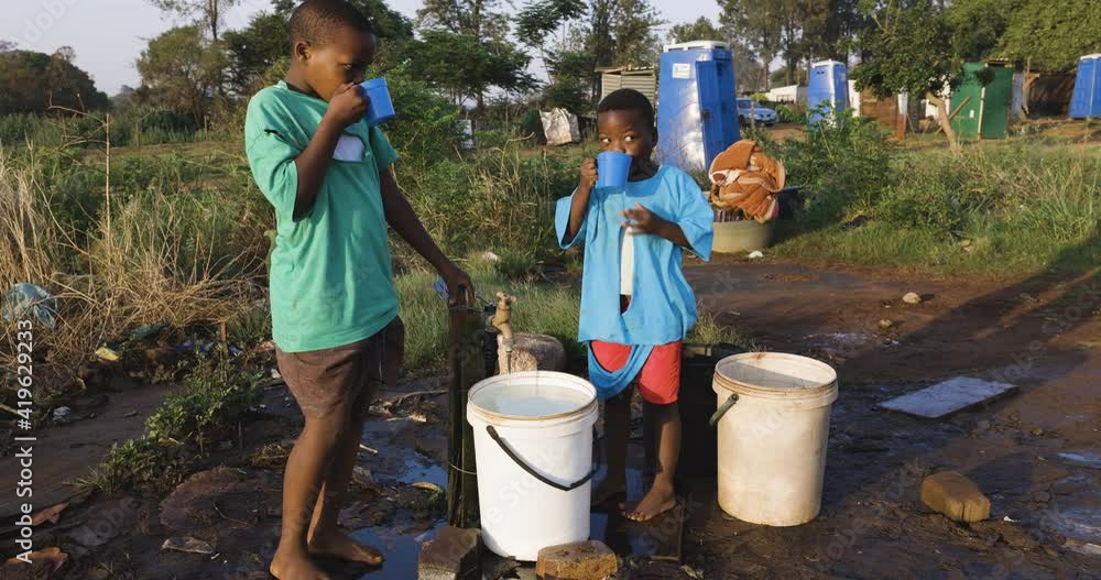 Water crisis. Close-up view of two young black African boys drinking ...