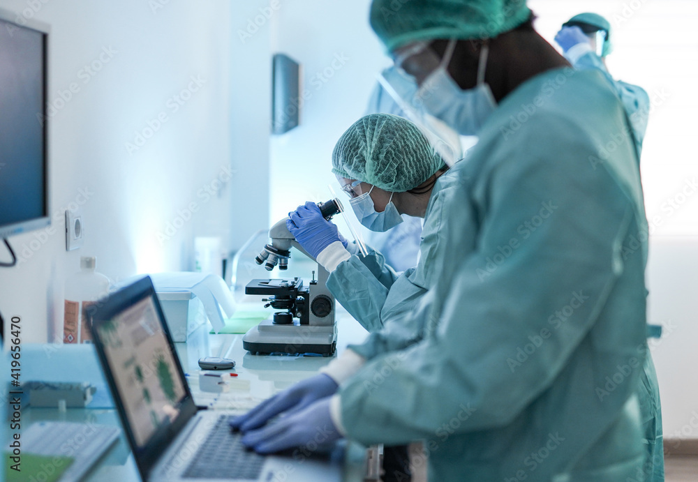 Scentist people working inside laboratory with microscope and laptop ...