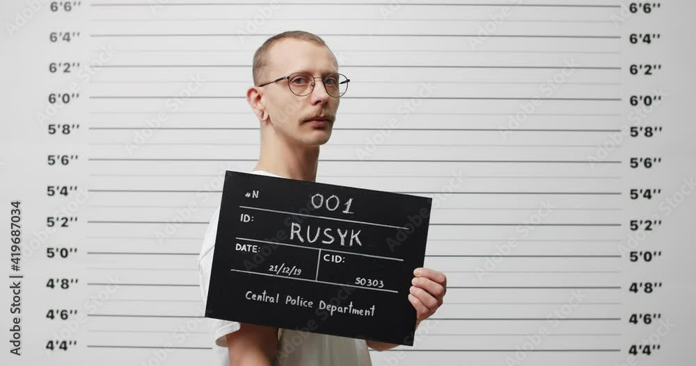Mugshot of arrested man in glasses with tattoos turning head and ...