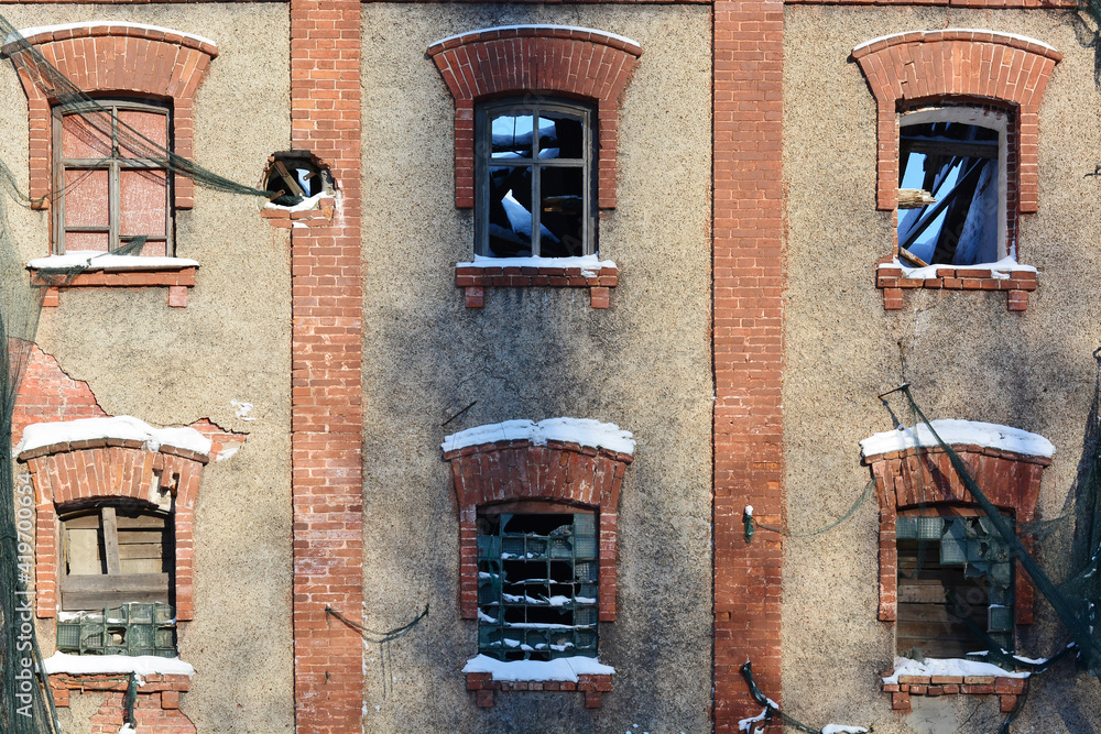 an old brick building with broken windows, through the windows you can ...