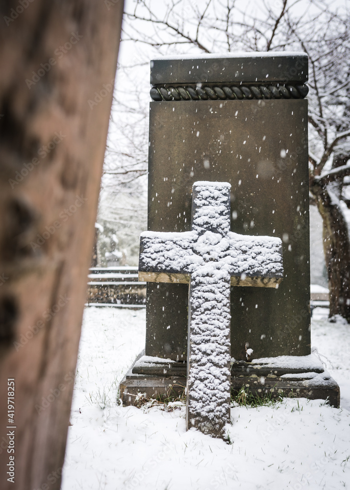 Broken old damaged cross gravestone leaning against headstone covered ...