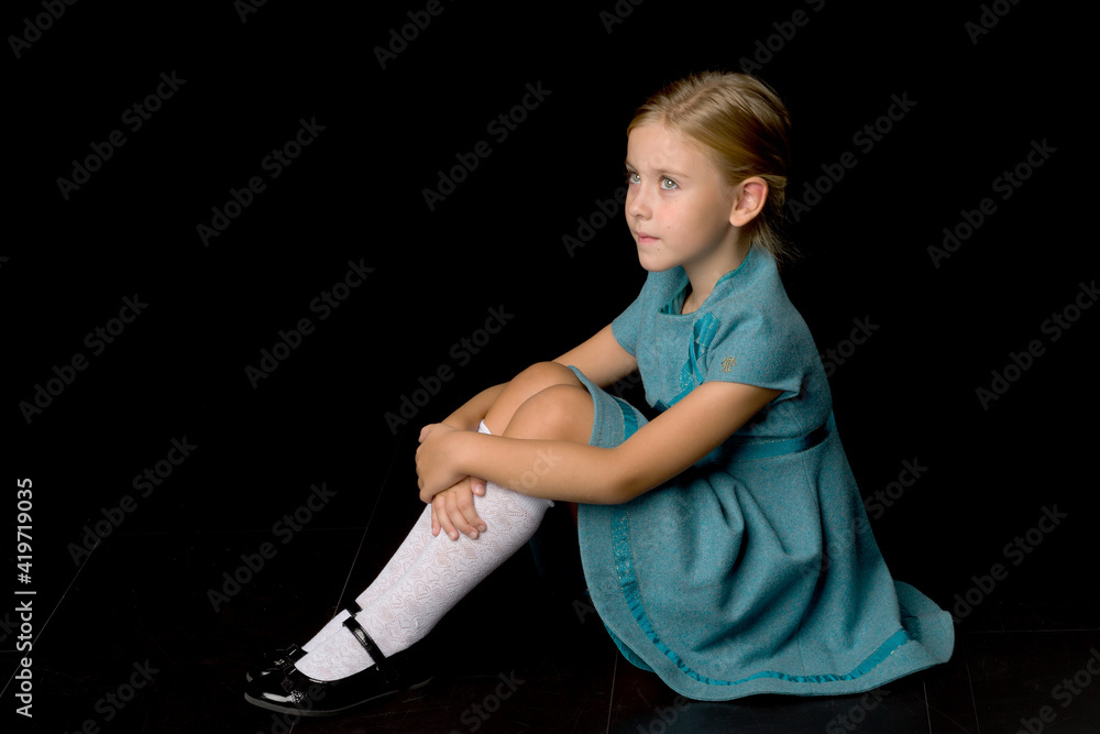 Cute girl sitting on floor hugging her knees Stock Photo | Adobe Stock